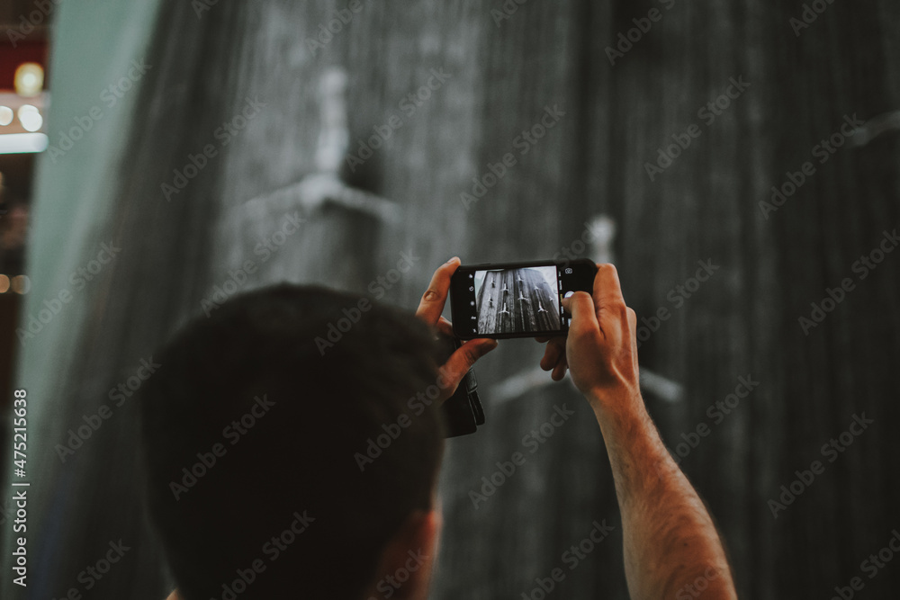 Person holding phone by taking pictures and videos on the modern ...