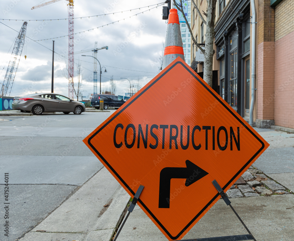 Under construction road signs on the road. Orange sign Construction on ...