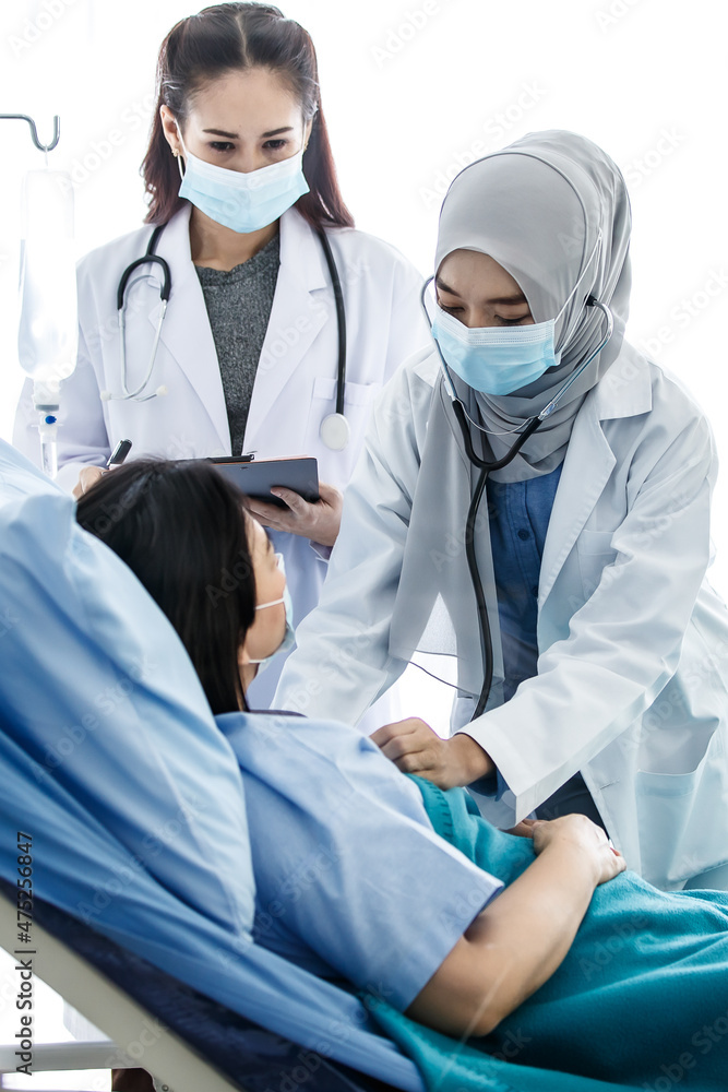 Muslim doctor in white lab coat with hijab and face mask using ...
