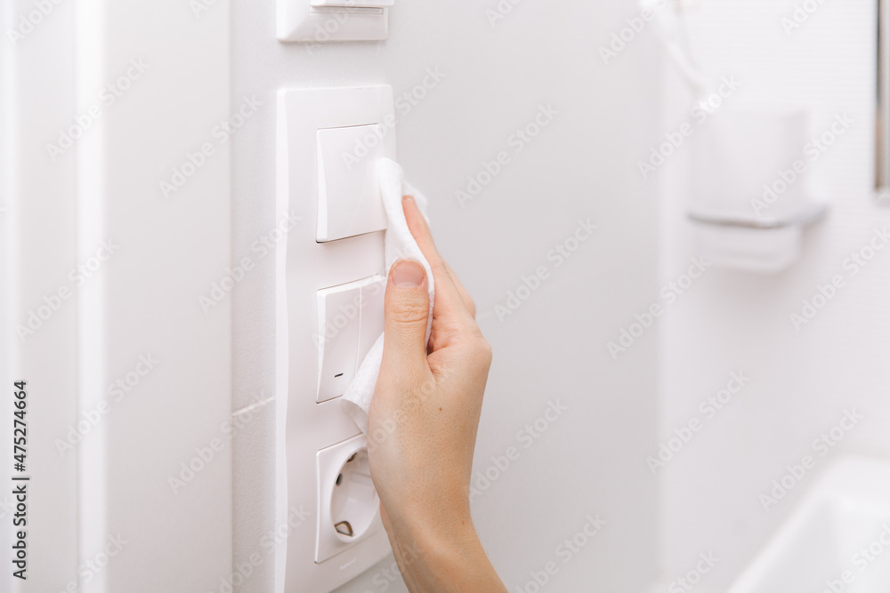 Cleaning switches and sockets with a microfiber cloth. Woman hand using ...