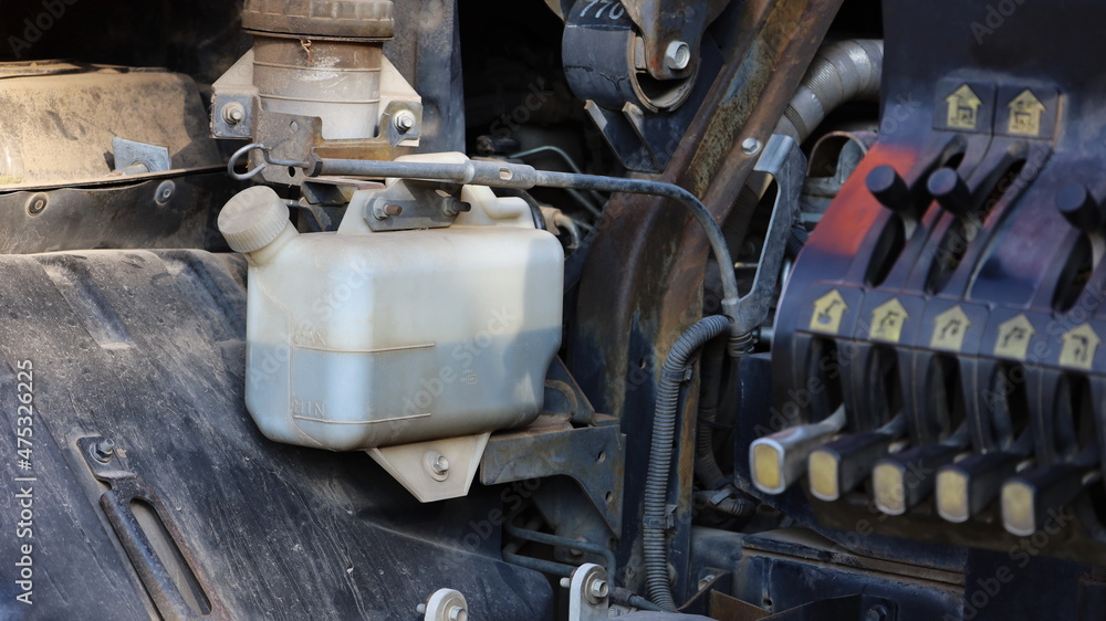 Truck coolant tank. White plastic tank with coolant on the side ...
