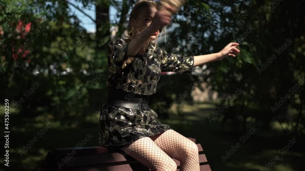 Drunken young woman with broken heart twirling flowers throwing bouquet away laughing out loud ...