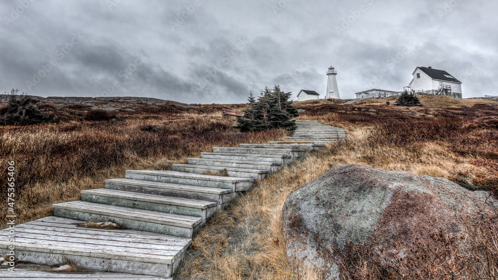 Wooden stairs leading to the houses on the mountain with a cloudy sky ...
