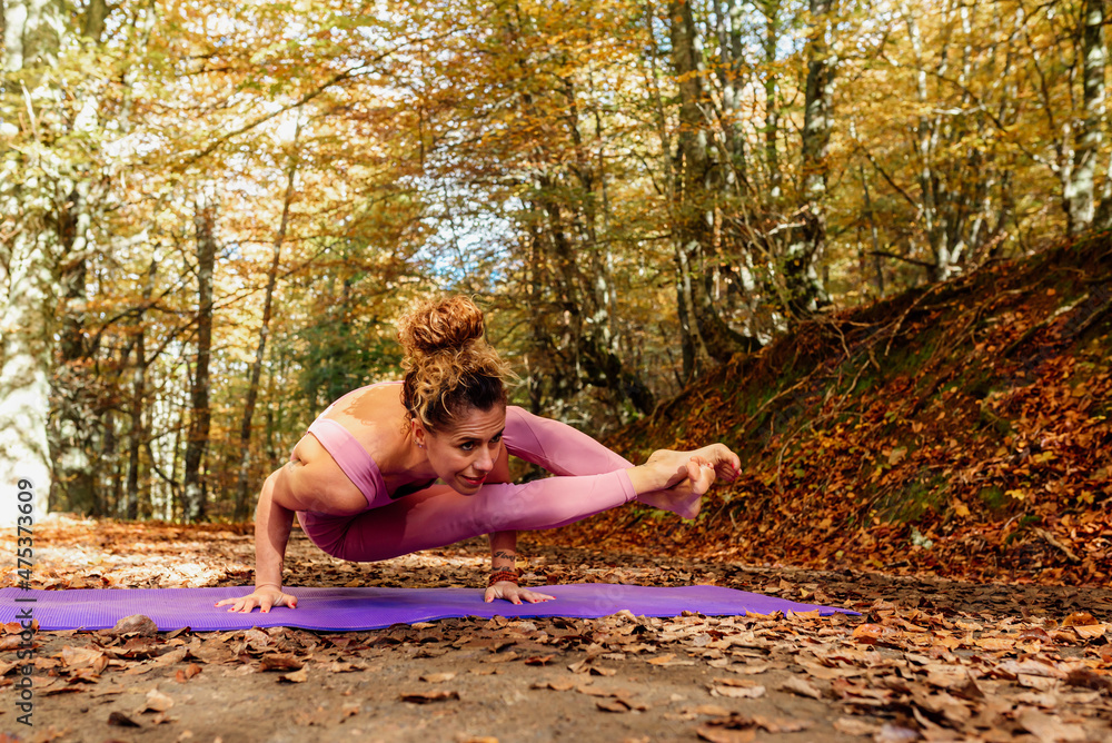 Strong woman practicing yoga, doing Eight Angle exercise, Astavakrasana ...