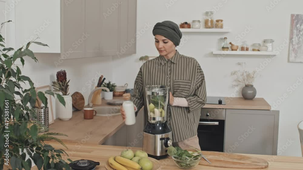 Beautiful Muslim Woman In Hijab Putting Spinach Leaves In Blender And