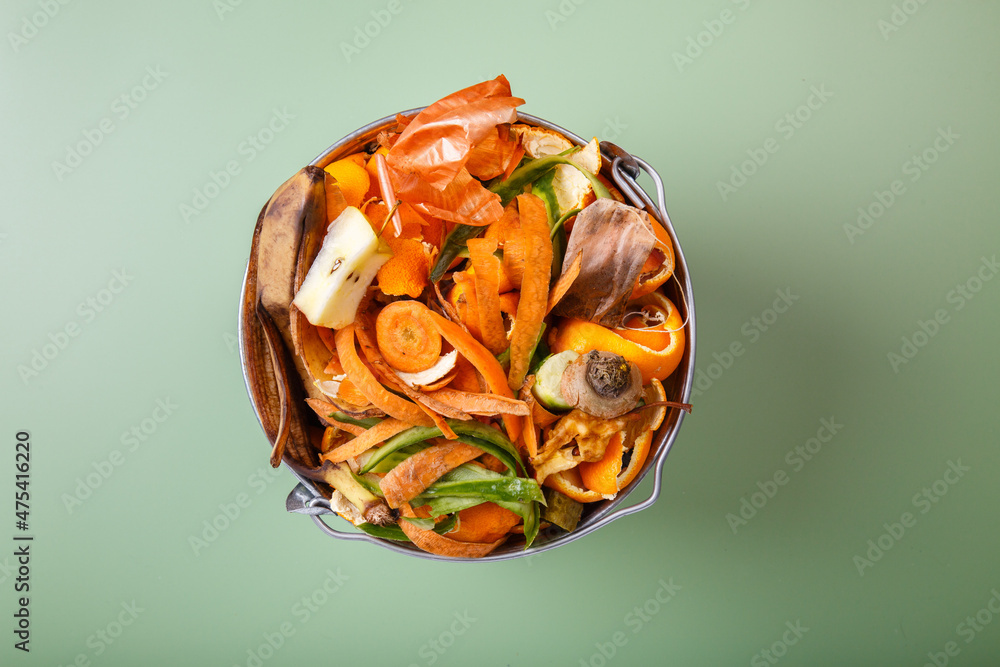 Sorted kitchen waste in compost-bucket on green background. Compost ...