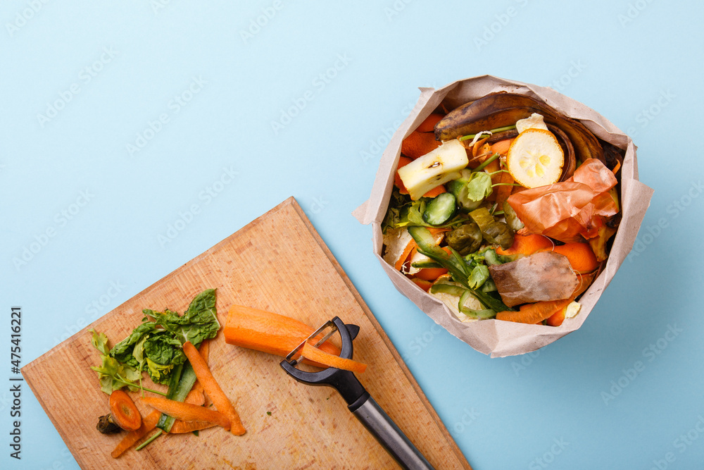 Sorted kitchen waste in paper eco bag on blue background. Compost ...
