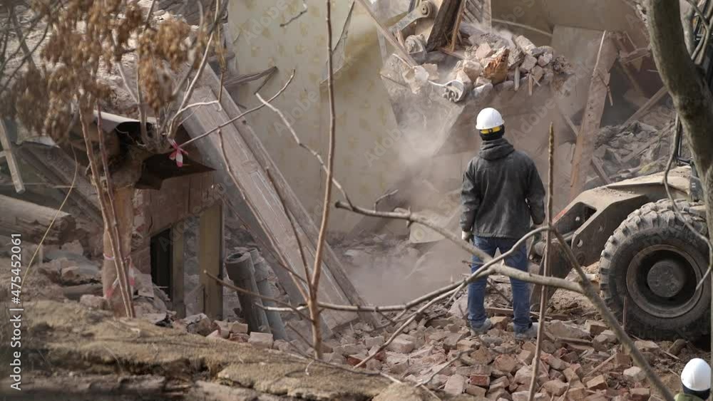 Engineer with protective helmet looks at demolition, destruction of old ...