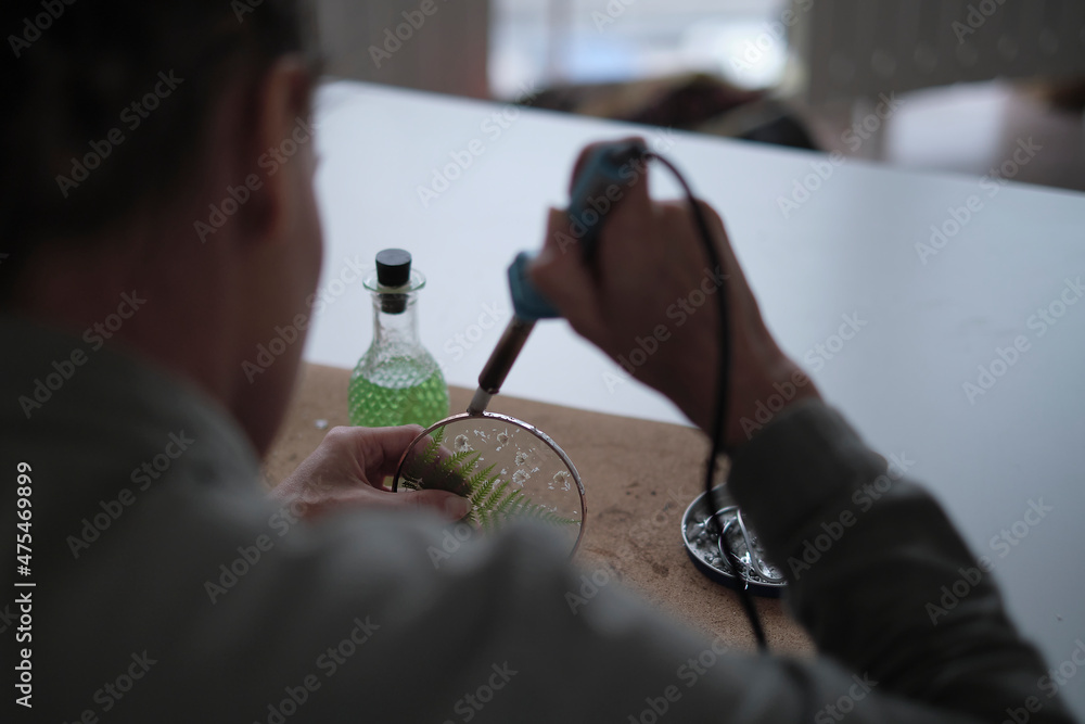 Stained glass maker works with colorful souvenirs. Female hands ...