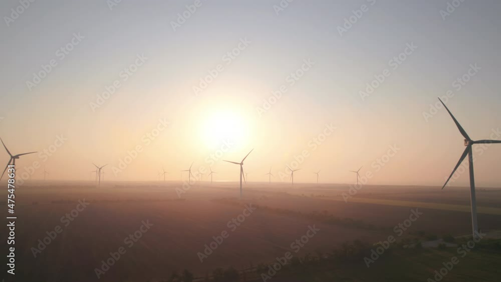 Windmills with rotating wings at sunrise or sunset or sunrise ...