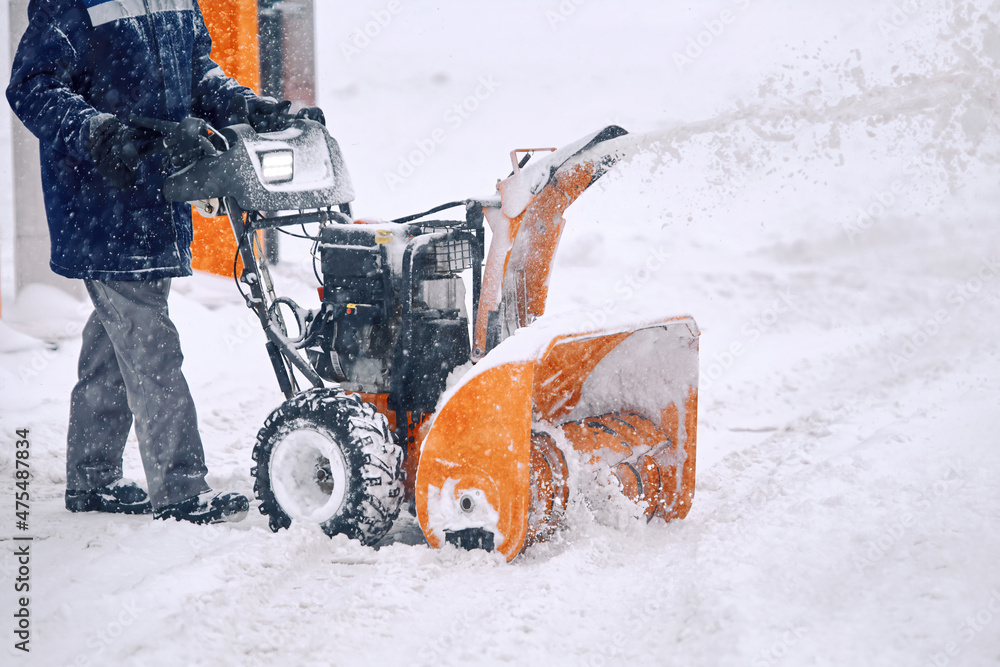 Snow blower machine during snowfall. Worker blowing snow during ...