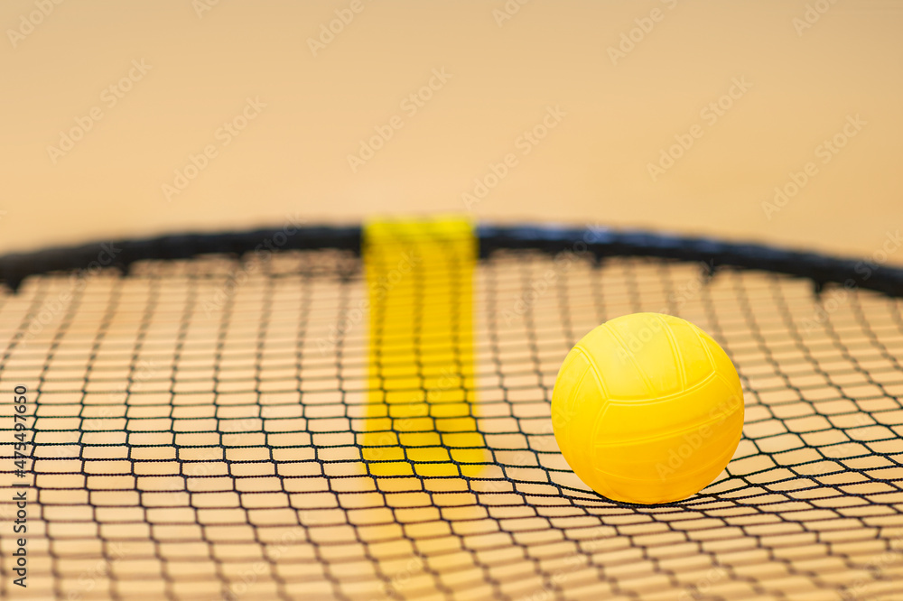 Spike ball game with yellow ball on camel color background. Horizontal ...