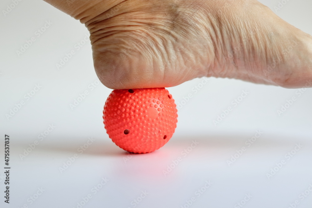 Relaxation of the muscles of the foot with a bandy ball, close-up. Heel ...