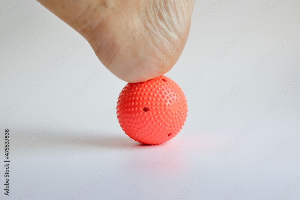 Relaxation of the muscles of the foot with a bandy ball, close-up. Heel ...