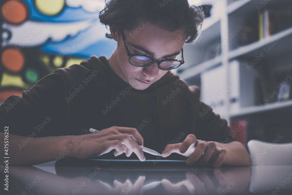 Teenager drawing with tablet and virtual pen. Millennial student doing ...