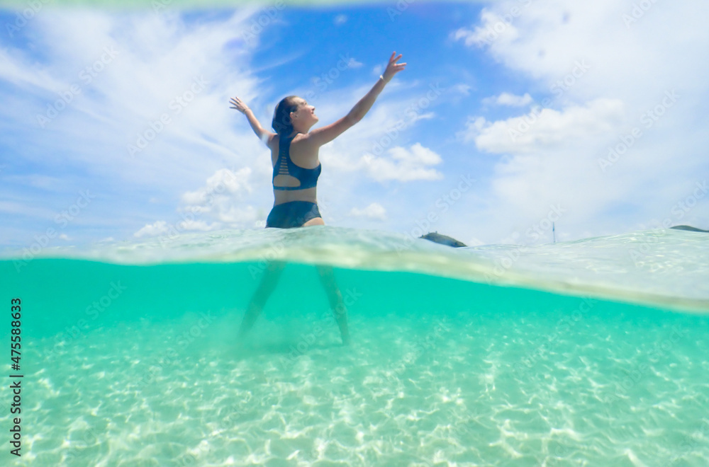 Beautiful female with a swimsuit posing in the transparent seawater on ...