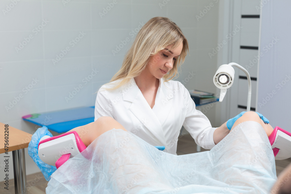 A gynecologist performs a colposcopy on a young girl in a gynecological ...