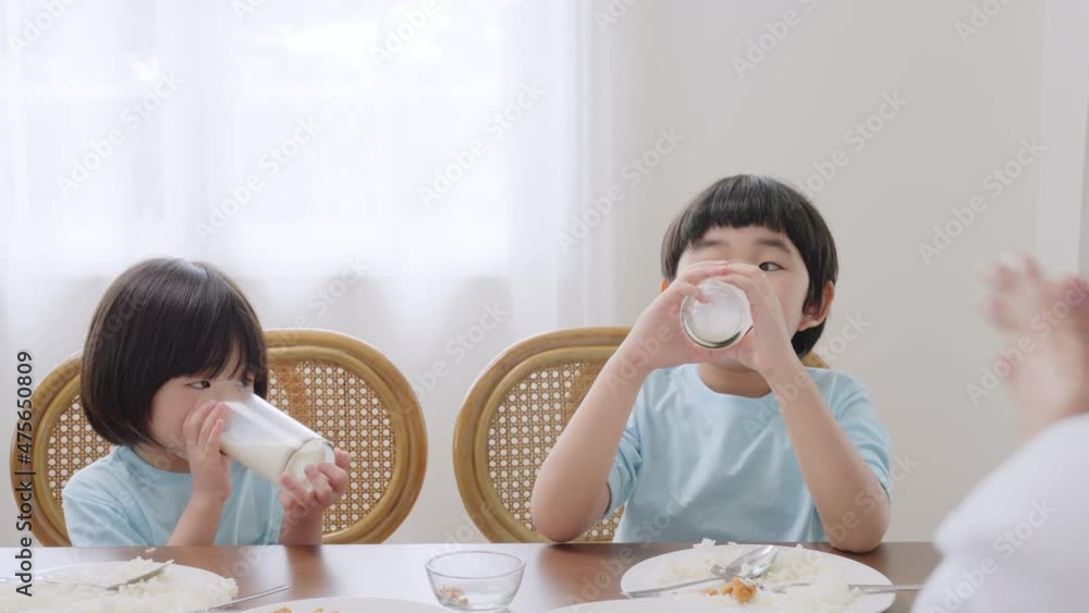 Son compete to drink milk together at a table connection and activities ...