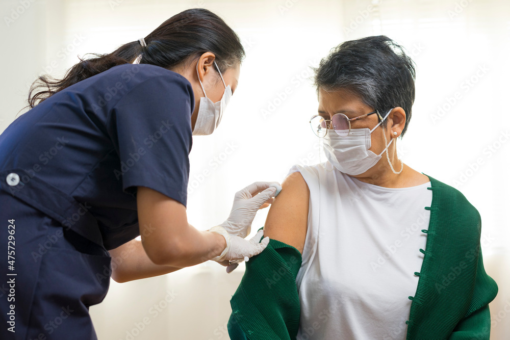 Nurse or doctor giving shot to senior female patient. Retired woman in ...