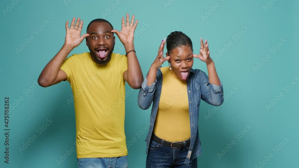 Man and woman sticking tongue out and fooling around in front of camera ...