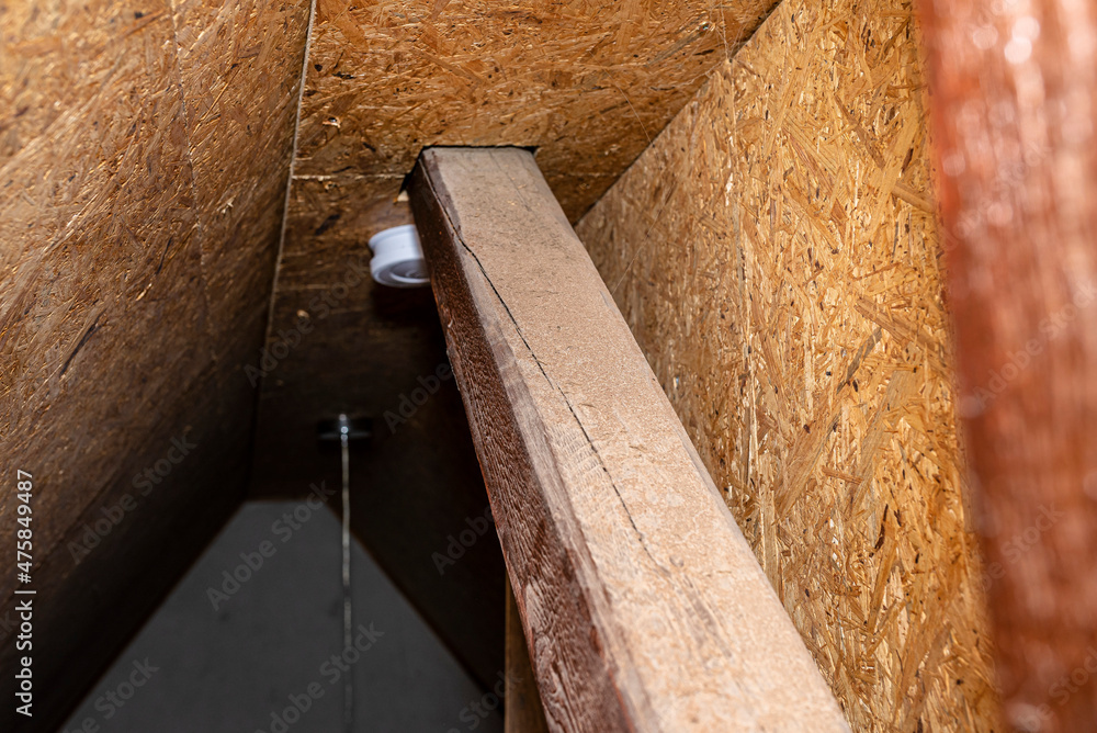 Roof truss visible in the attic house, painted brown with visible ...