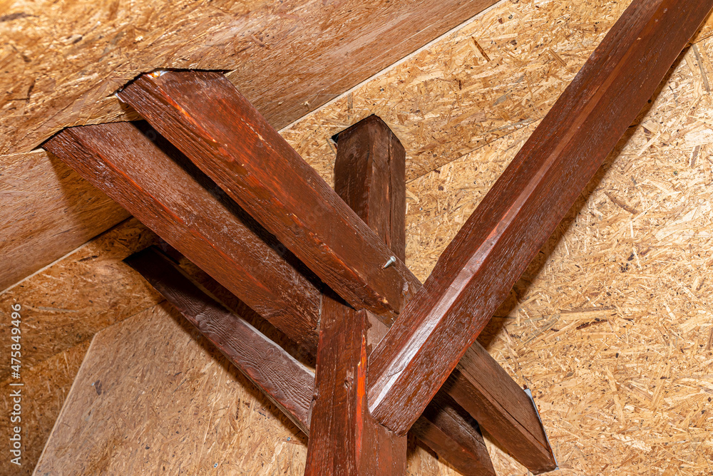 Roof truss visible in the attic house, painted brown with visible ...
