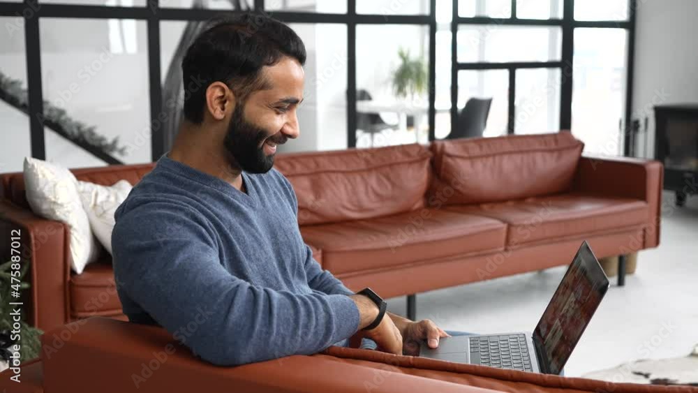 Smiling positive Indian man take a part in online webinar, using ...