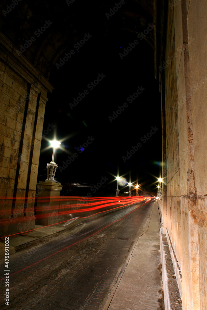 Cars driving over Arch on the dam wall at night with cars driving over ...