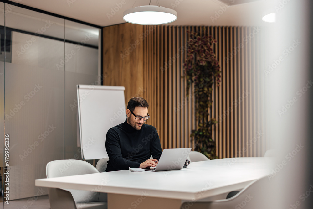 Hardworking adult man, typing fast on his laptop keyboard in the office ...