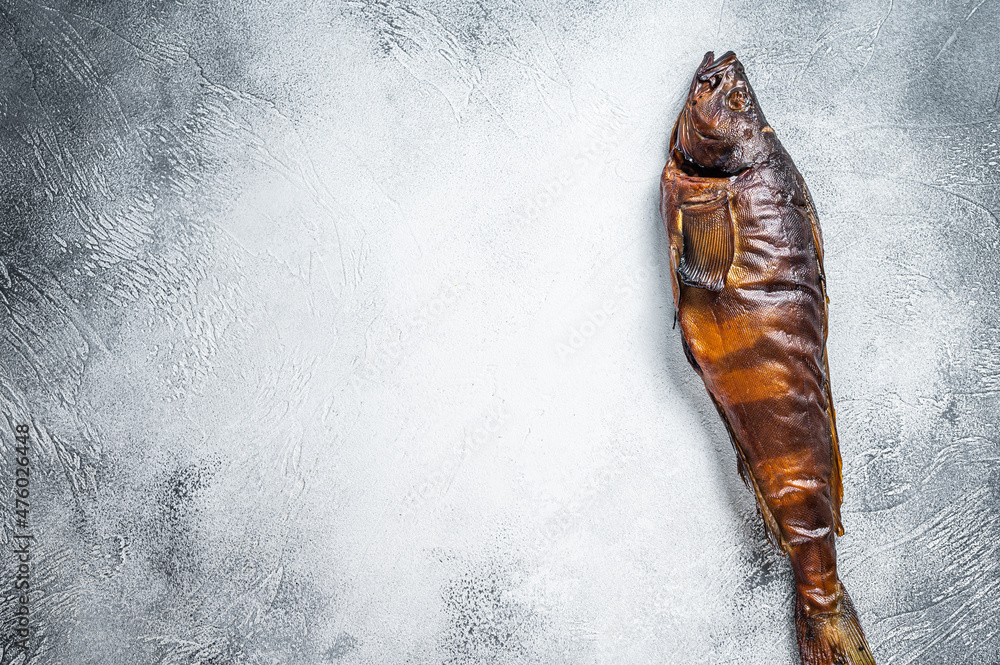 Hot smoked whole fish on kitchen table. White background. Top view ...