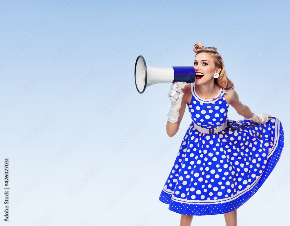 Portrait of woman holding megaphone loudspeaker, dressed in pinup style ...