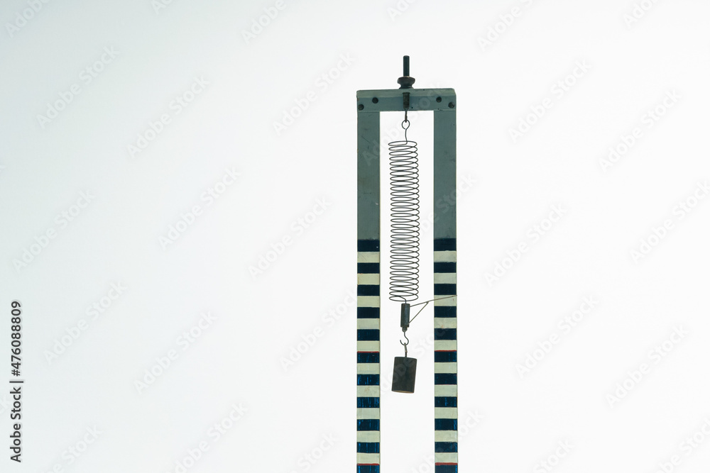 Weight hangs from a metal spring. Used for a vibration experiment or to ...