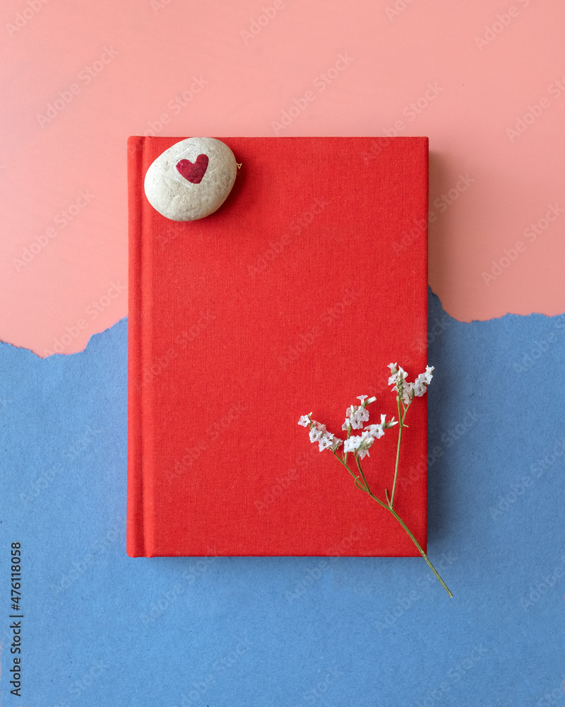 Bright red book on the pink background with a cute stone and drawn ...