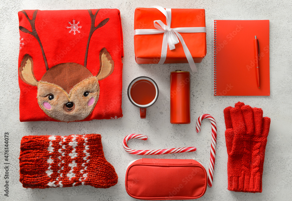 Composition with warm clothes, Christmas gift and cup of tea on light ...