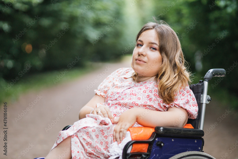 Pretty young woman who using wheelchair relaxing alone on fresh air ...