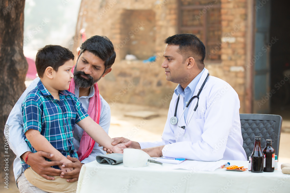 Indian Doctor examine little kid boy patient at village, Father with ...