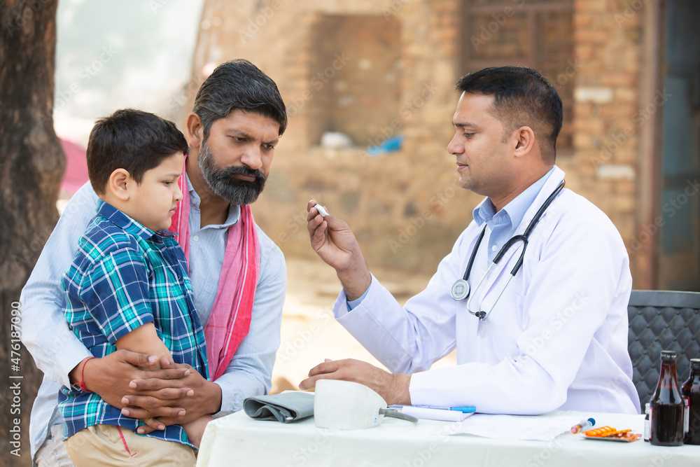 Indian Doctor examine little kid boy patient fever at village with ...