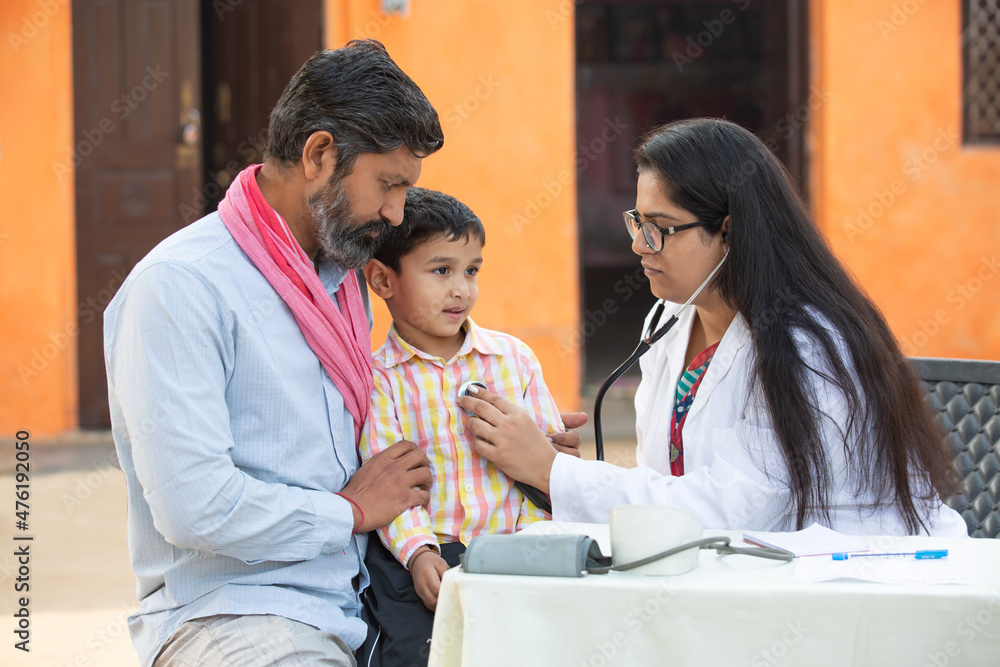 Indian female doctor with stethoscope checking little child patient ...