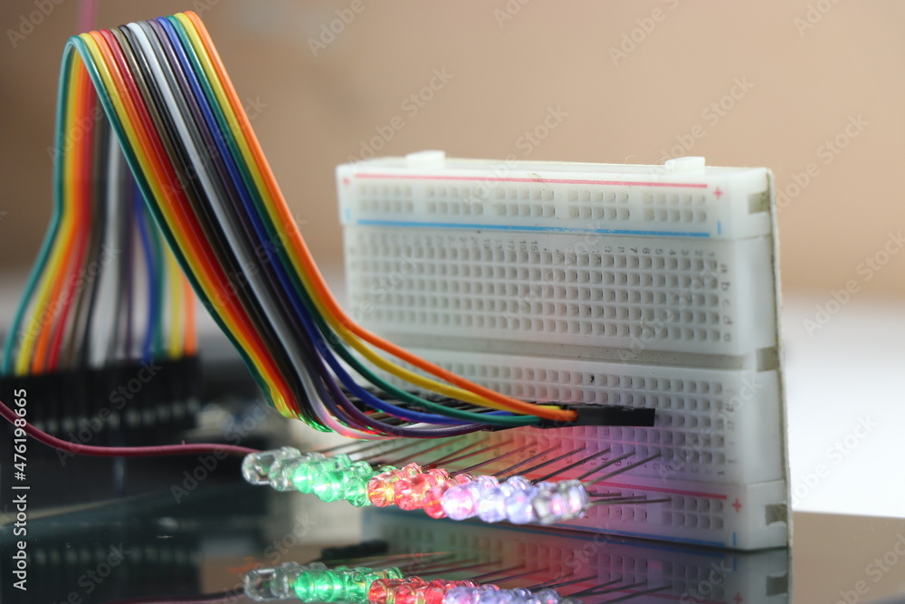 Breadboard with glowing lights from LED with reflections on the glass ...