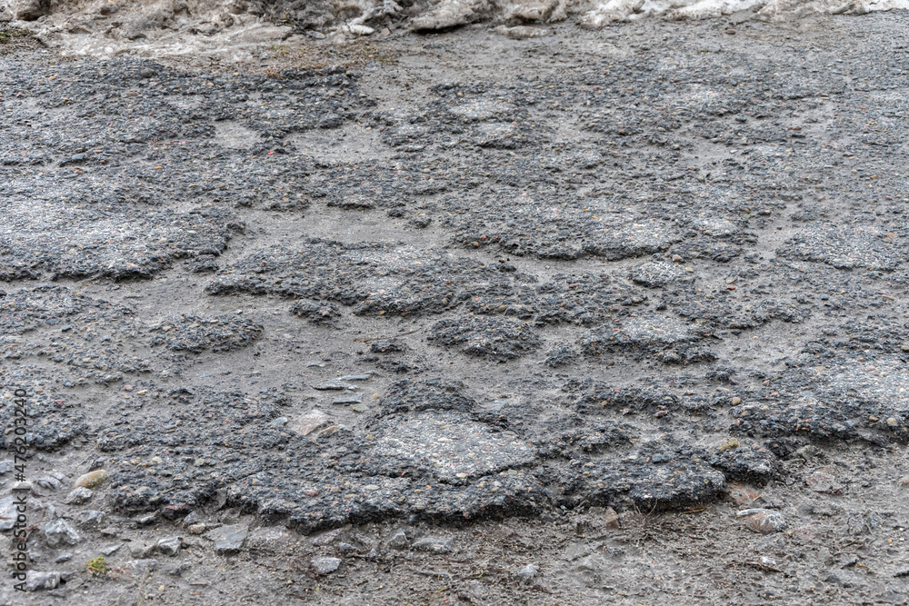 Small potholes on the asphalt road, pits and destroyed road surface ...