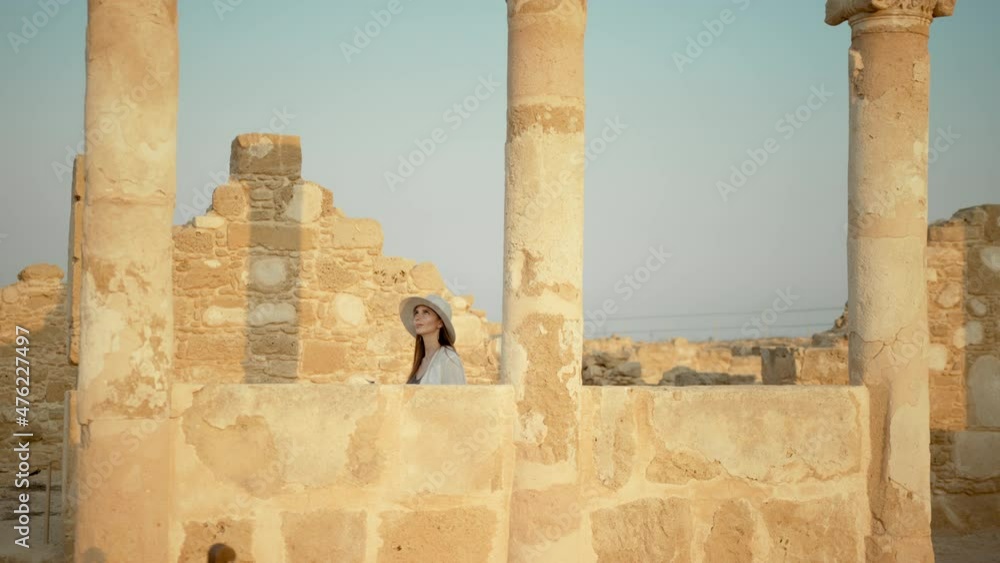 Competent female archeologist standing among ruins of ancient temple ...