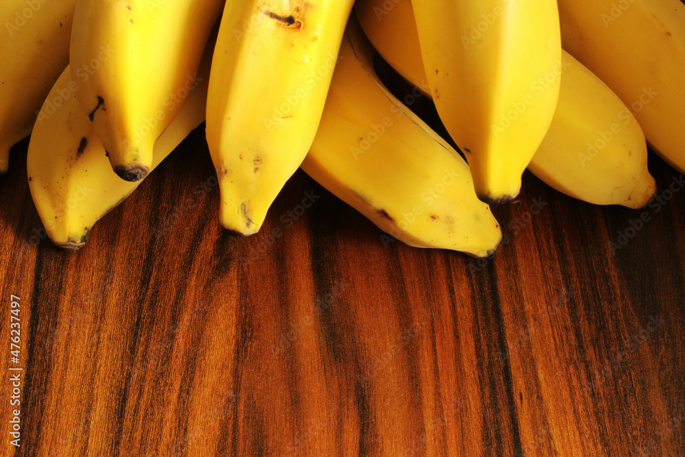 Bananas. Bunch of Bananas at the top of the frame with a wooden ...