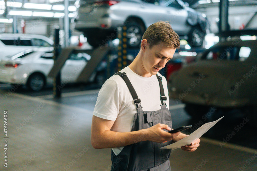 Side view of professional handsome young mechanic male wearing uniform ...