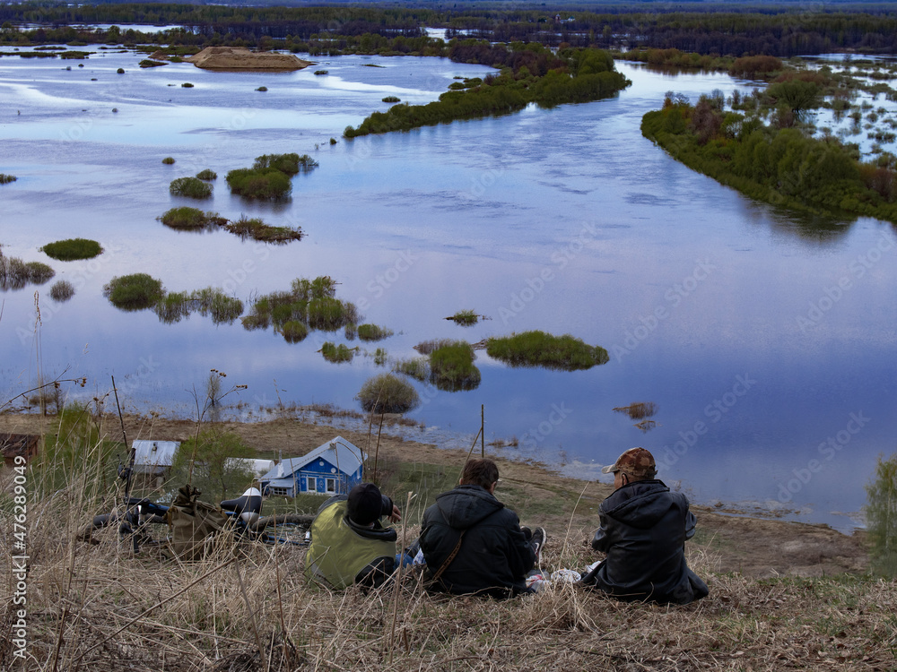 People on the bank are watching the flood of the river. A painting ...
