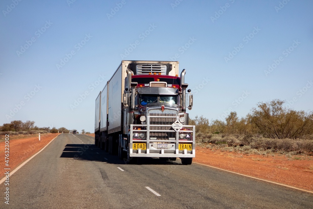 Red Kenworth heavy road train trucks transporting heavy load in three ...