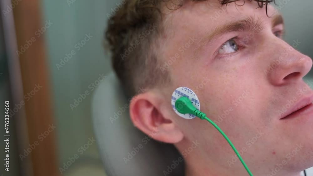 young guy on the procedure Transcutaneous electrical nerve stimulation, before installing the ...