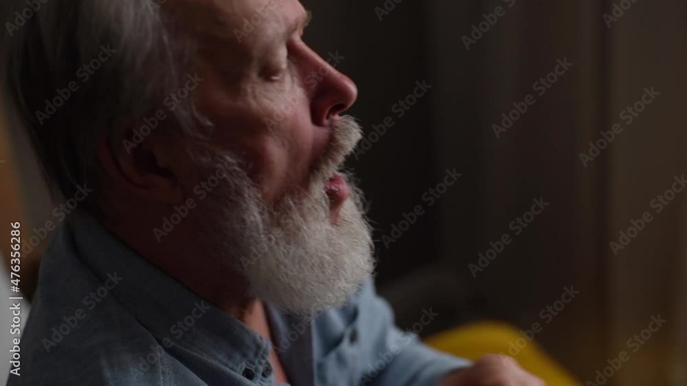 Close-up face of sick gray-haired mature adult male coughing violently ...