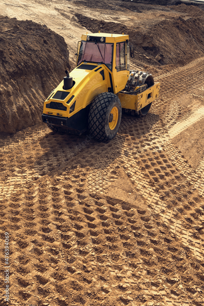 The vibratory roller compacts the soil in the excavation Stock Photo ...