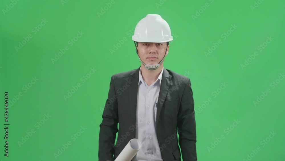 Asian Chief Engineer In The Hard Hat Holding Blueprint And Walks On ...