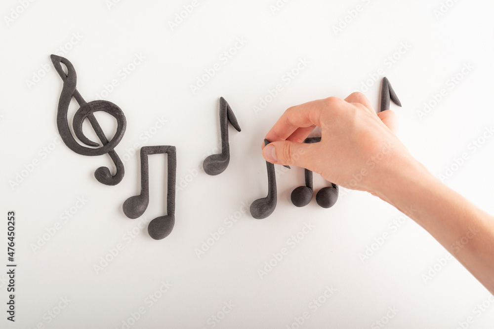 Treble clef and musical note in child hands on white background. Key of ...
